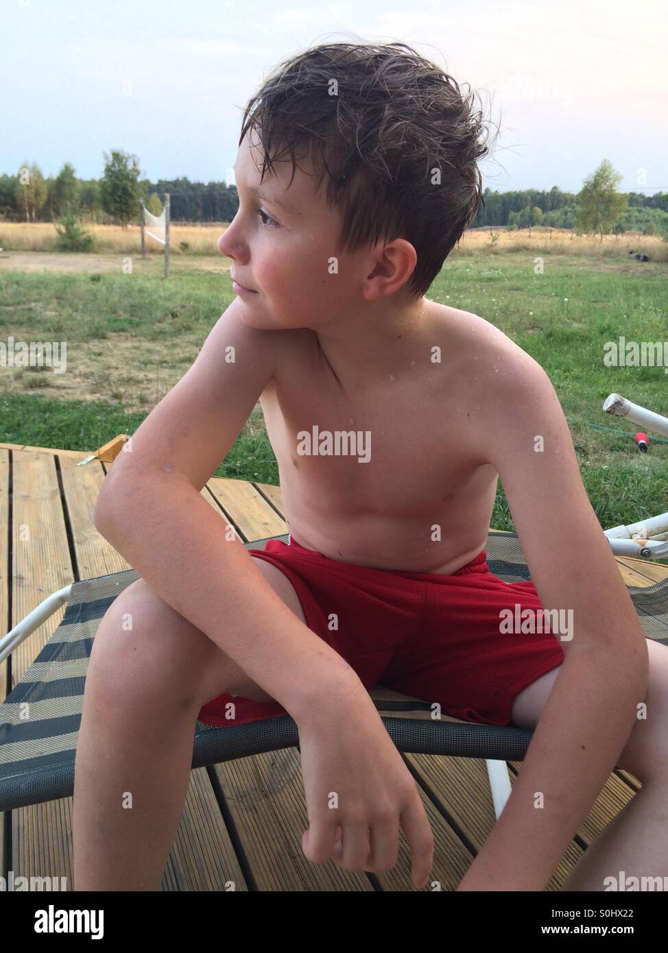 Boy Sitting On A Sunbed Outside Stock Photo Alamy boy-sitting-on-a-sunbed-outside-stock-photo-alamy