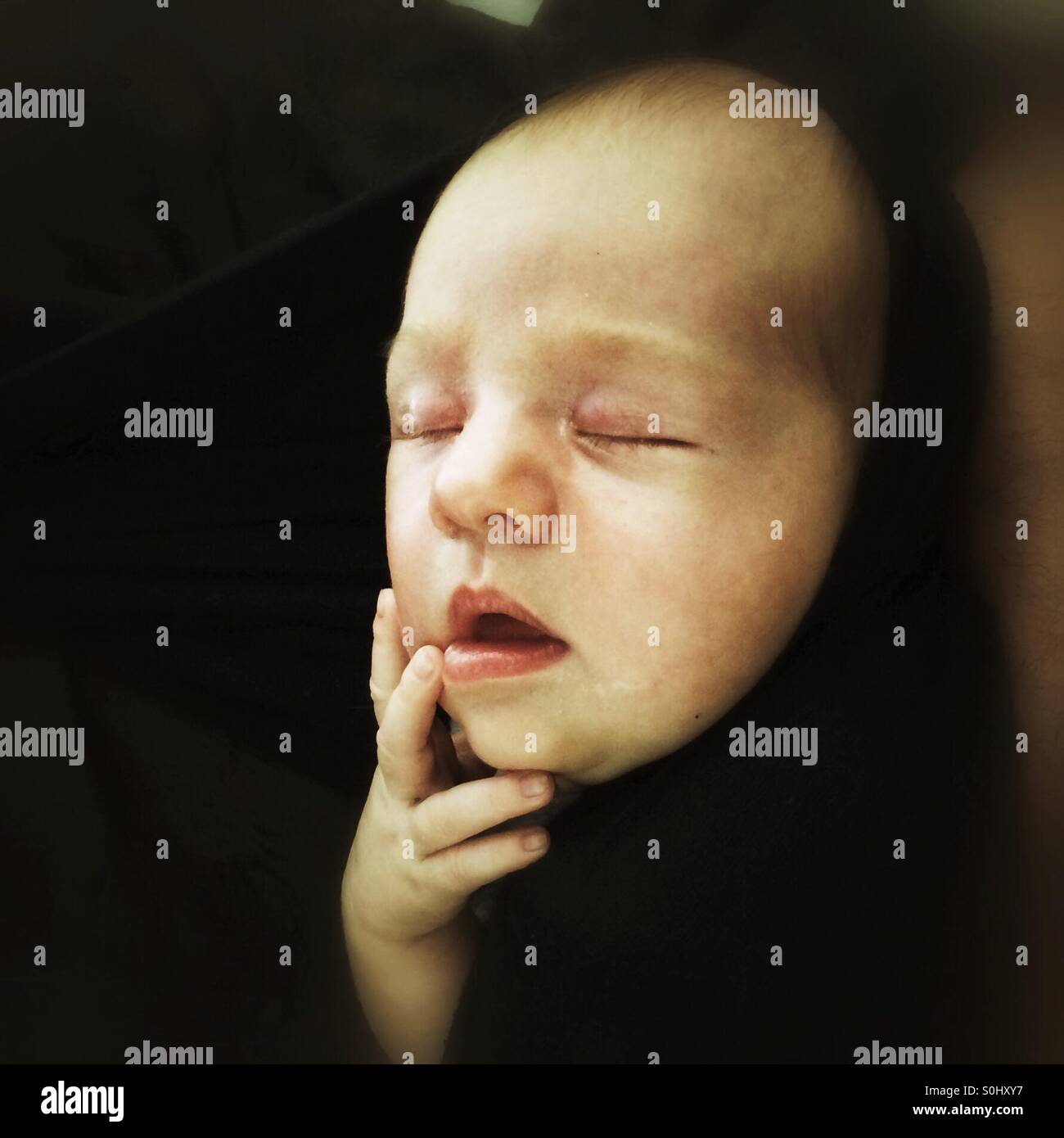 Baby touching her face Stock Photo - Alamy