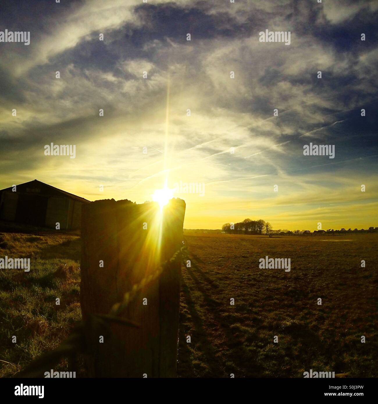 Sunset over farmland Stock Photo - Alamy