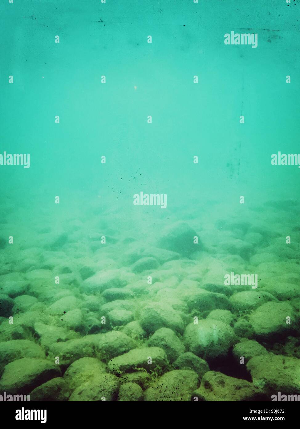 Rocky bottom of lake. Turquoise waters above. Photo taken underwater ...