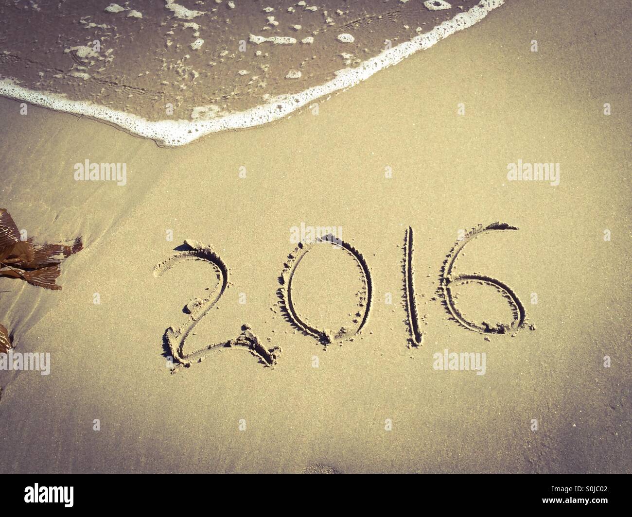 The year 2016 written in the sand Stock Photo - Alamy