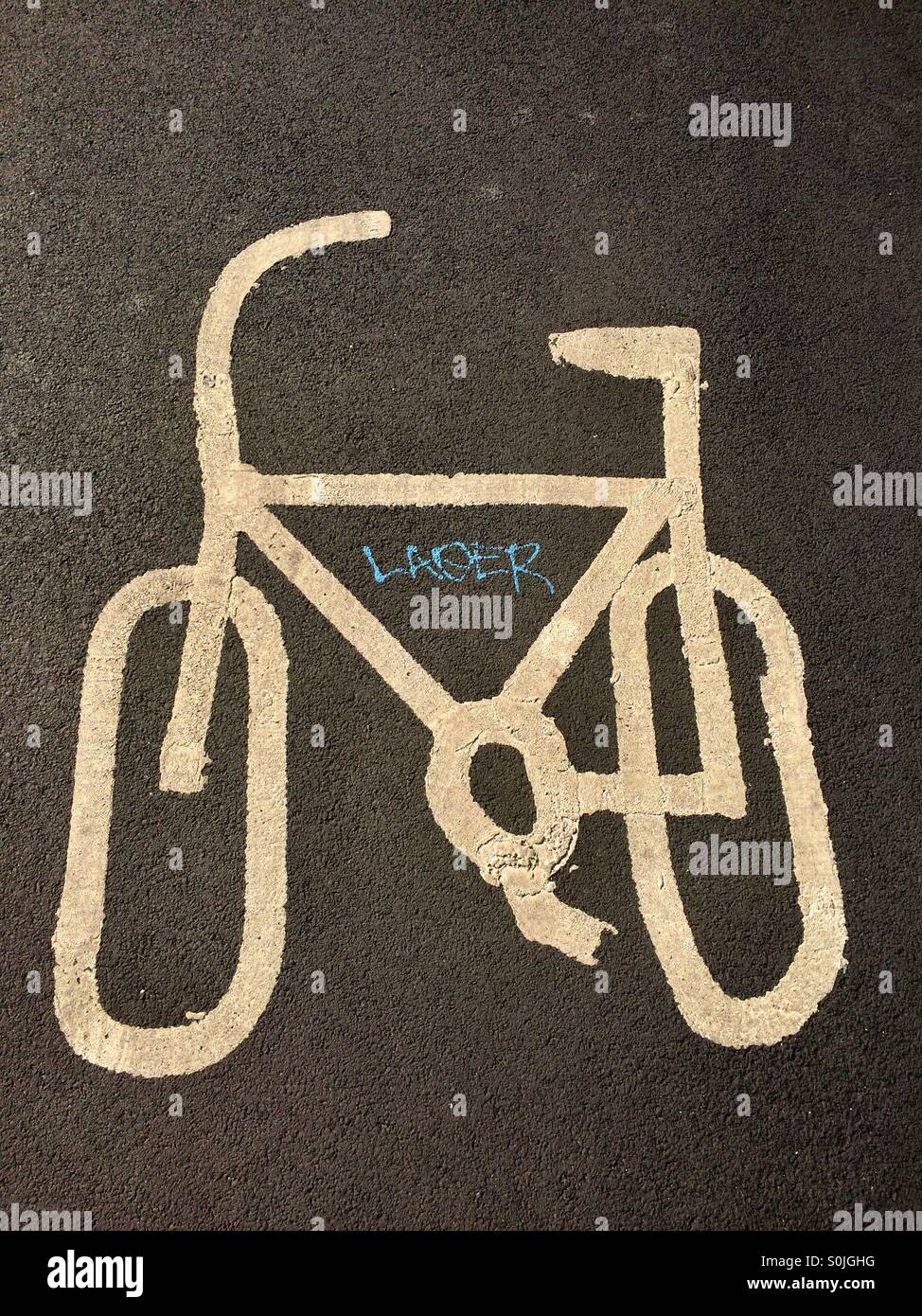 Cycling sign on ground with graffiti Stock Photo - Alamy