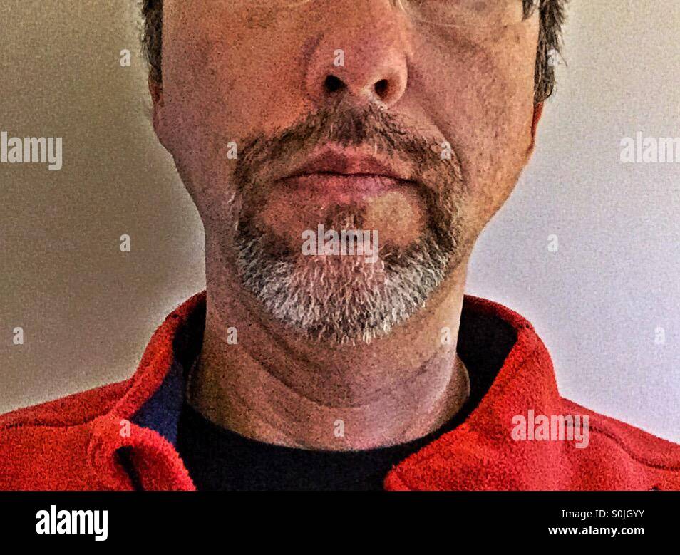 Unsmiling man with goatee and red sweater Stock Photo - Alamy