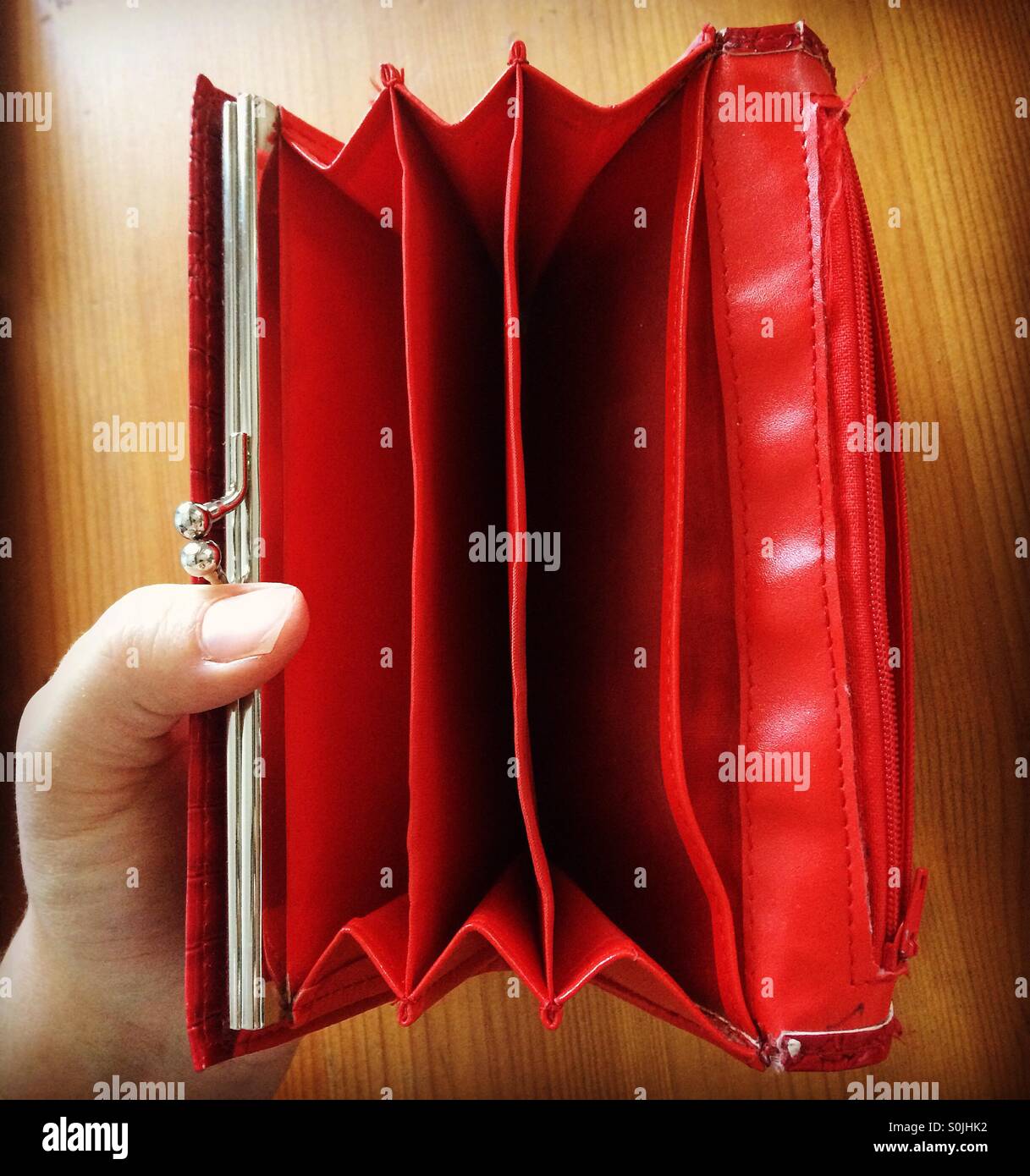 View from the top on an empty red leather wallet with few compartments ...