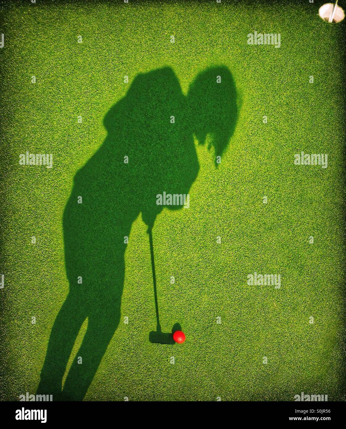 Shadow of Young girl putting on artificial grass Stock Photo - Alamy