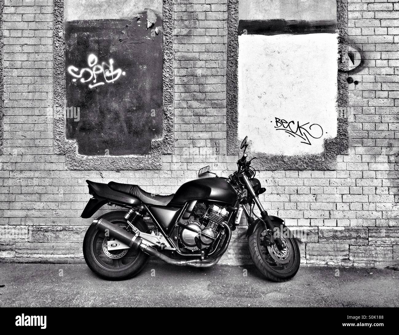 Generic motorcycle against a brick wall Stock Photo - Alamy