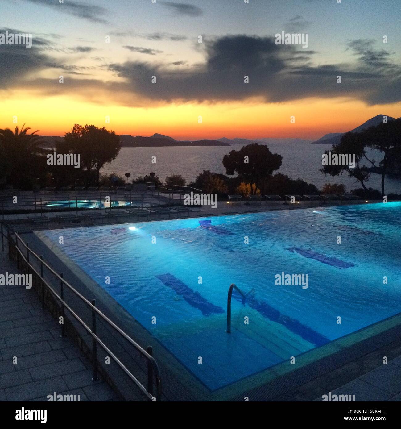 Infinity pool at sunset Stock Photo - Alamy