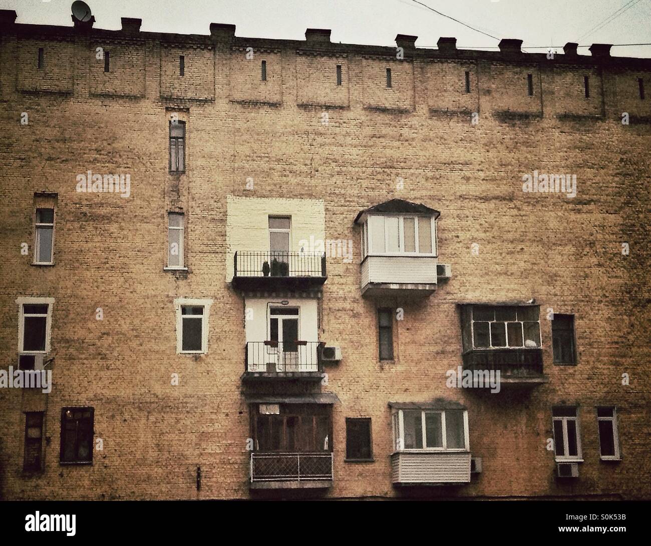 Wall of a building with asymmetrically located windows and balconies ...