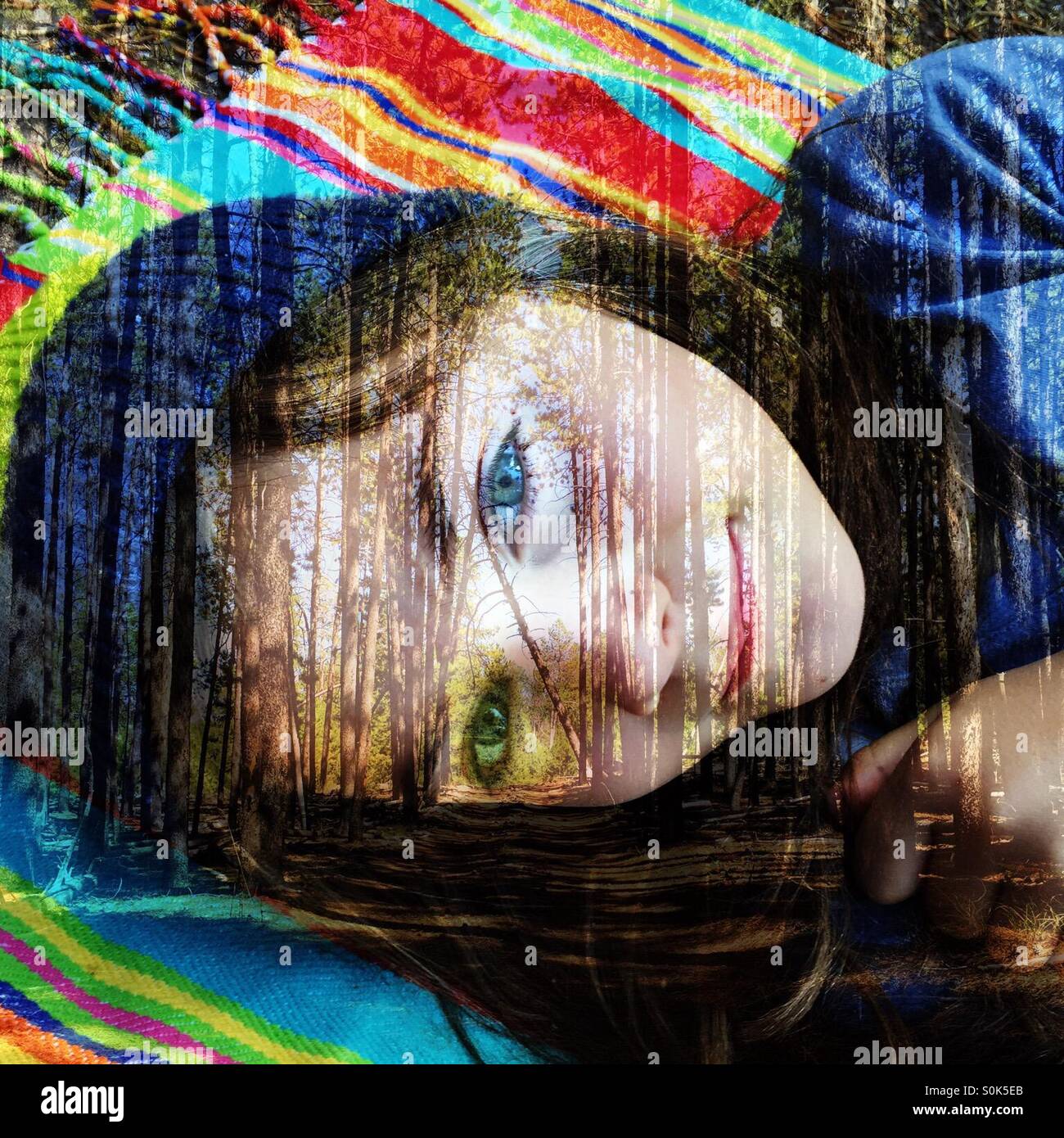 A double-exposure of a young girl with bright blue-eyes and a forest ...
