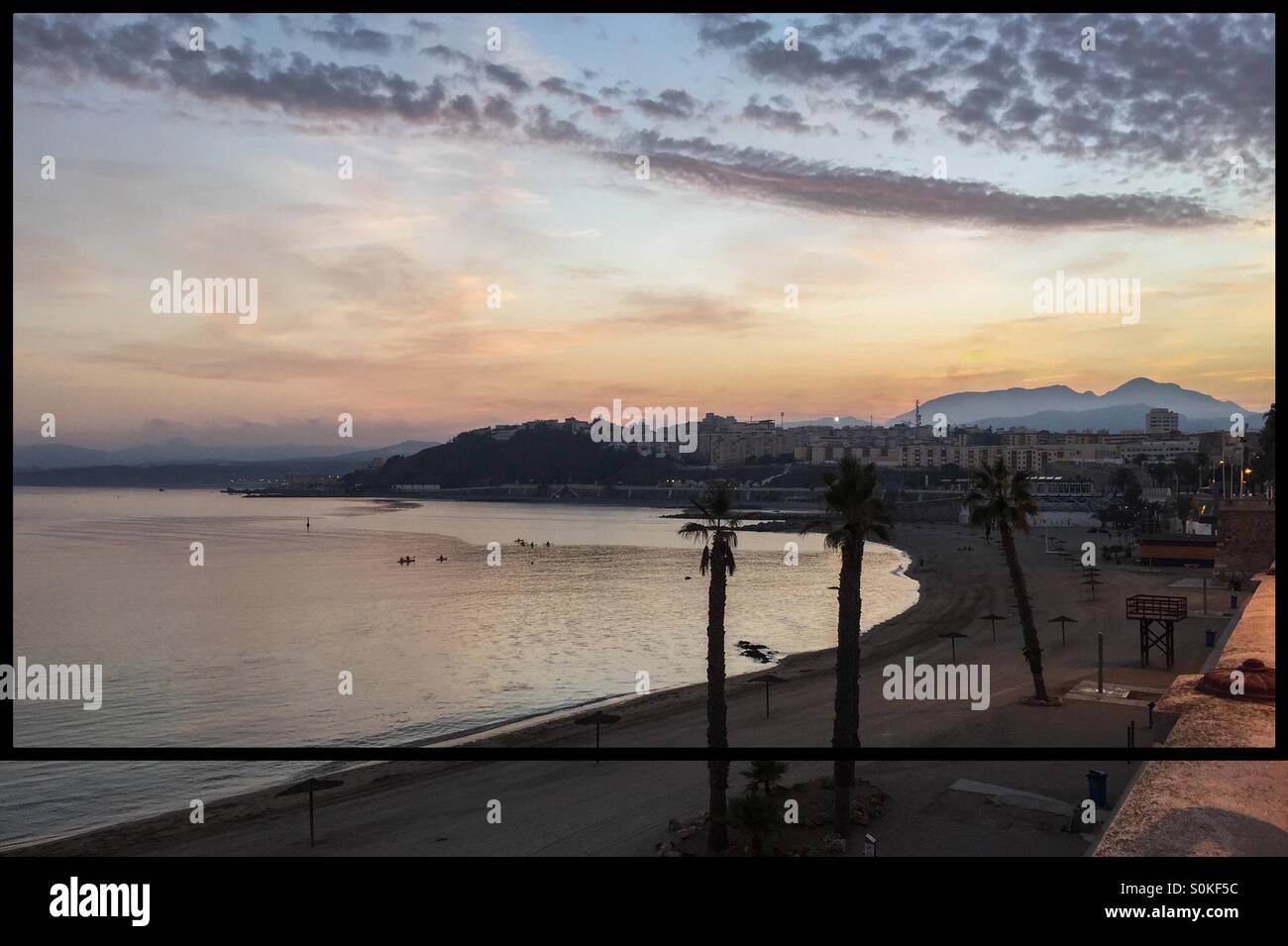 Sunset at Ceuta beach with Morocco in background Stock Photo - Alamy