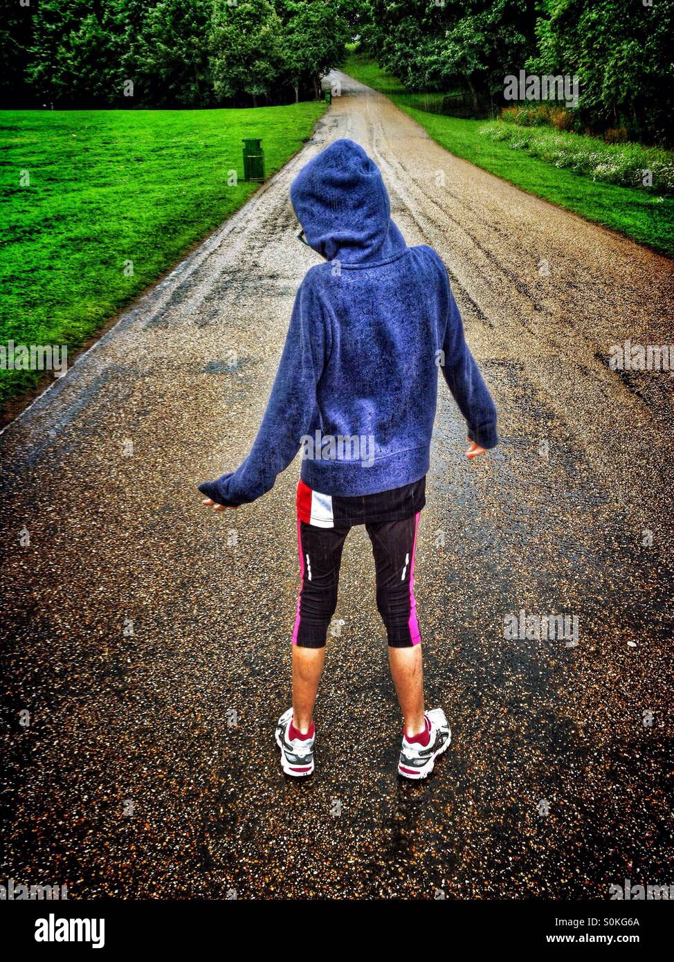 Young girl preparing to run in the rain Stock Photo - Alamy