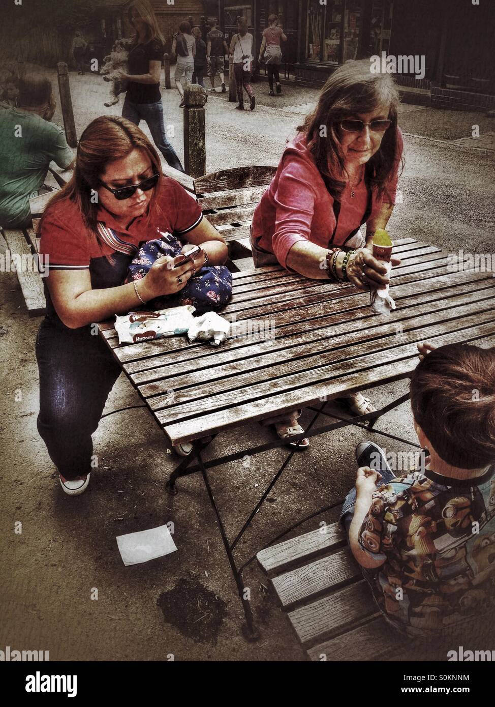 A family sat outside at a trestle table enjoying refreshments Stock ...