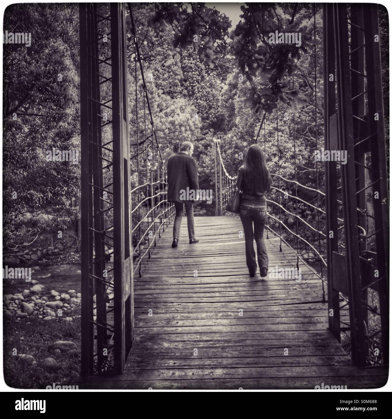 Couple crossing bridge Stock Photo - Alamy