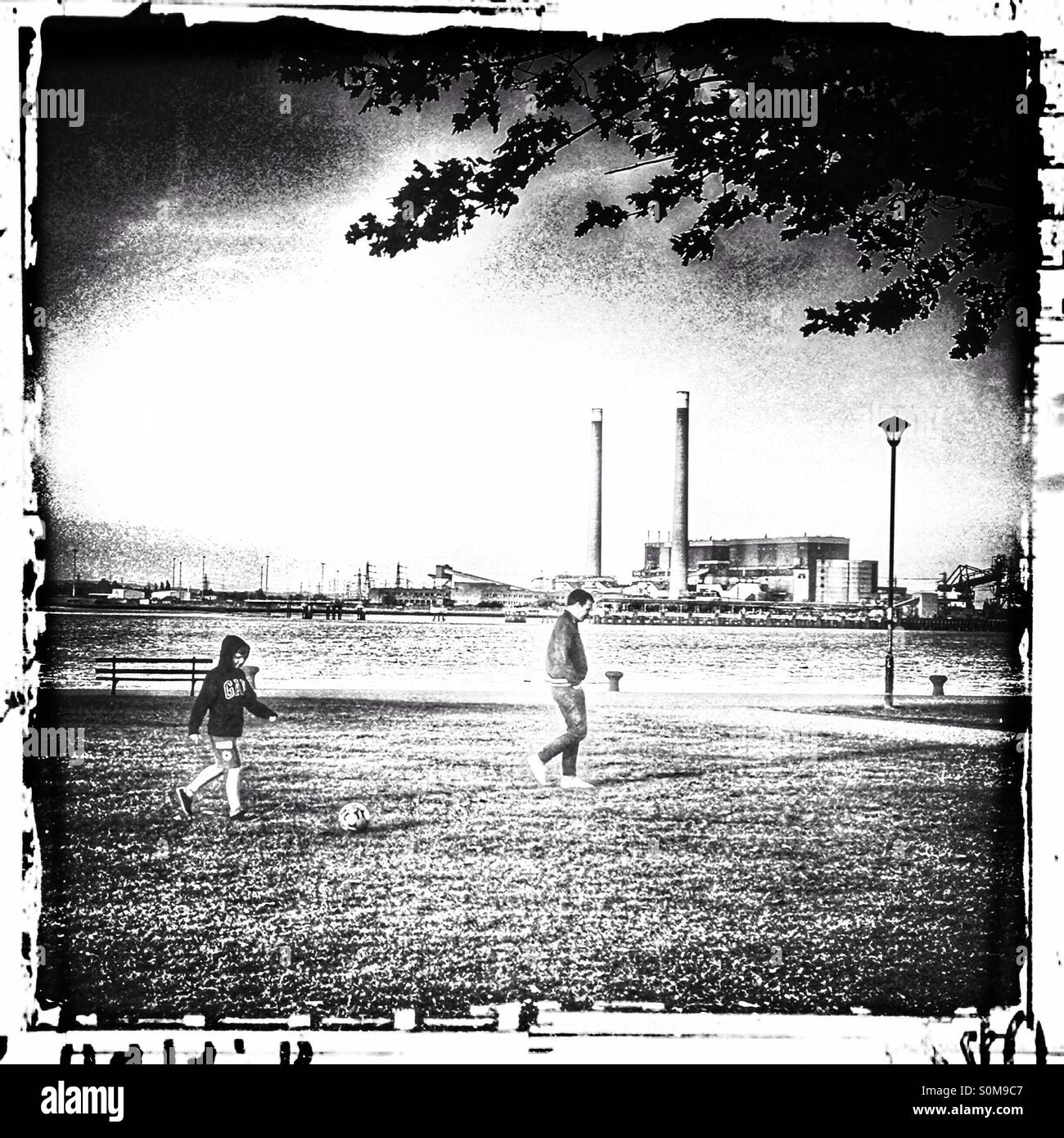 Father and son in park showing the Tilbury power stations in distance ...