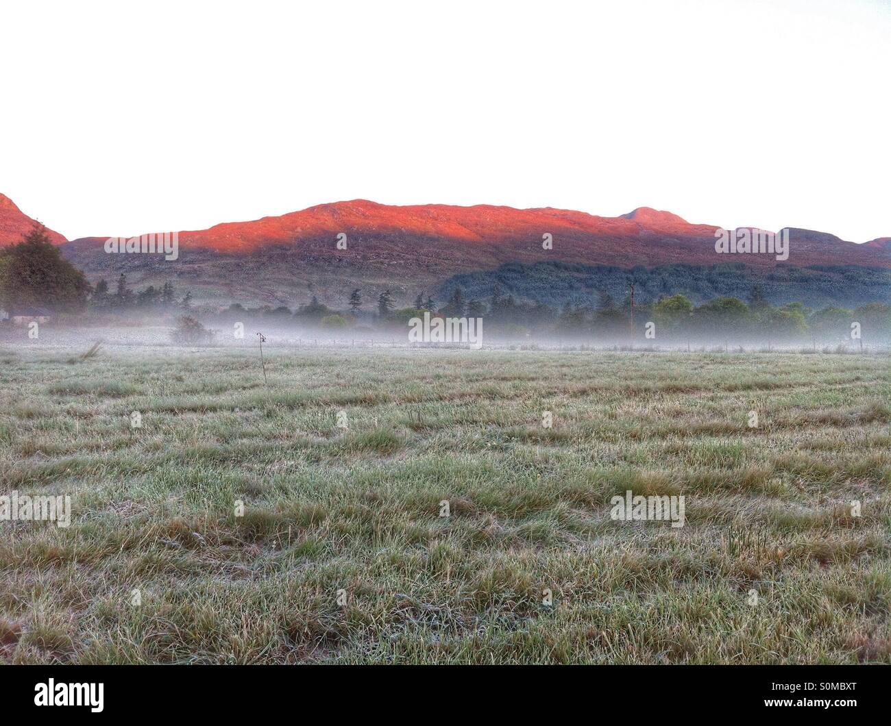 The sun rises over a misty Scottish highland valley Stock Photo - Alamy