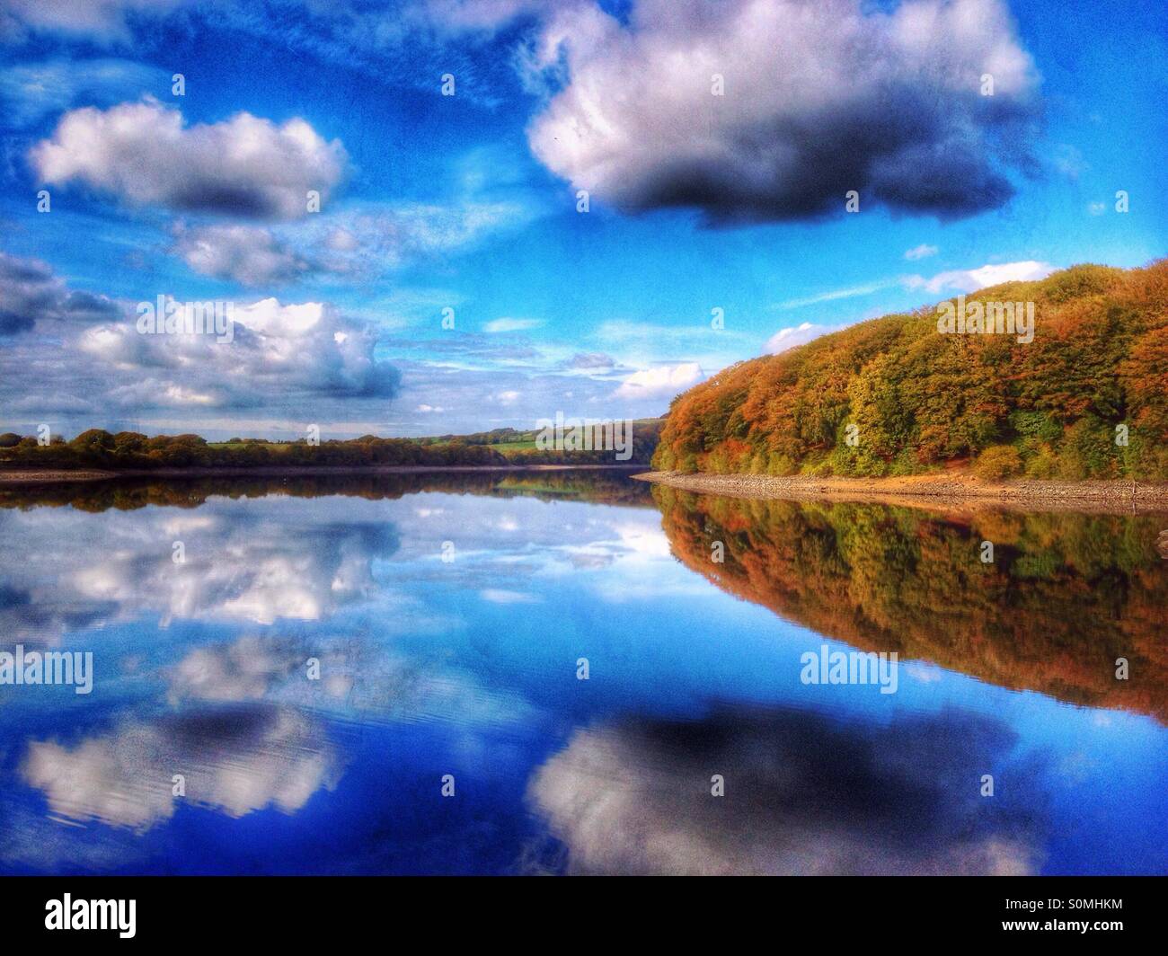 Mirror image reflection of clouds and trees in Anglezarke reservoir in ...