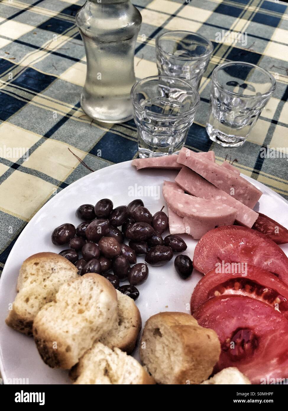 greek raki and some traditional food on table Stock Photo - Alamy