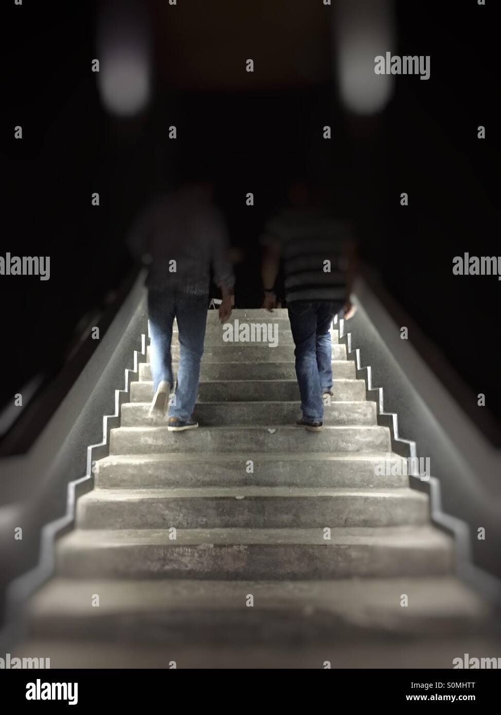 Two men climbing up the stairs at night Stock Photo - Alamy