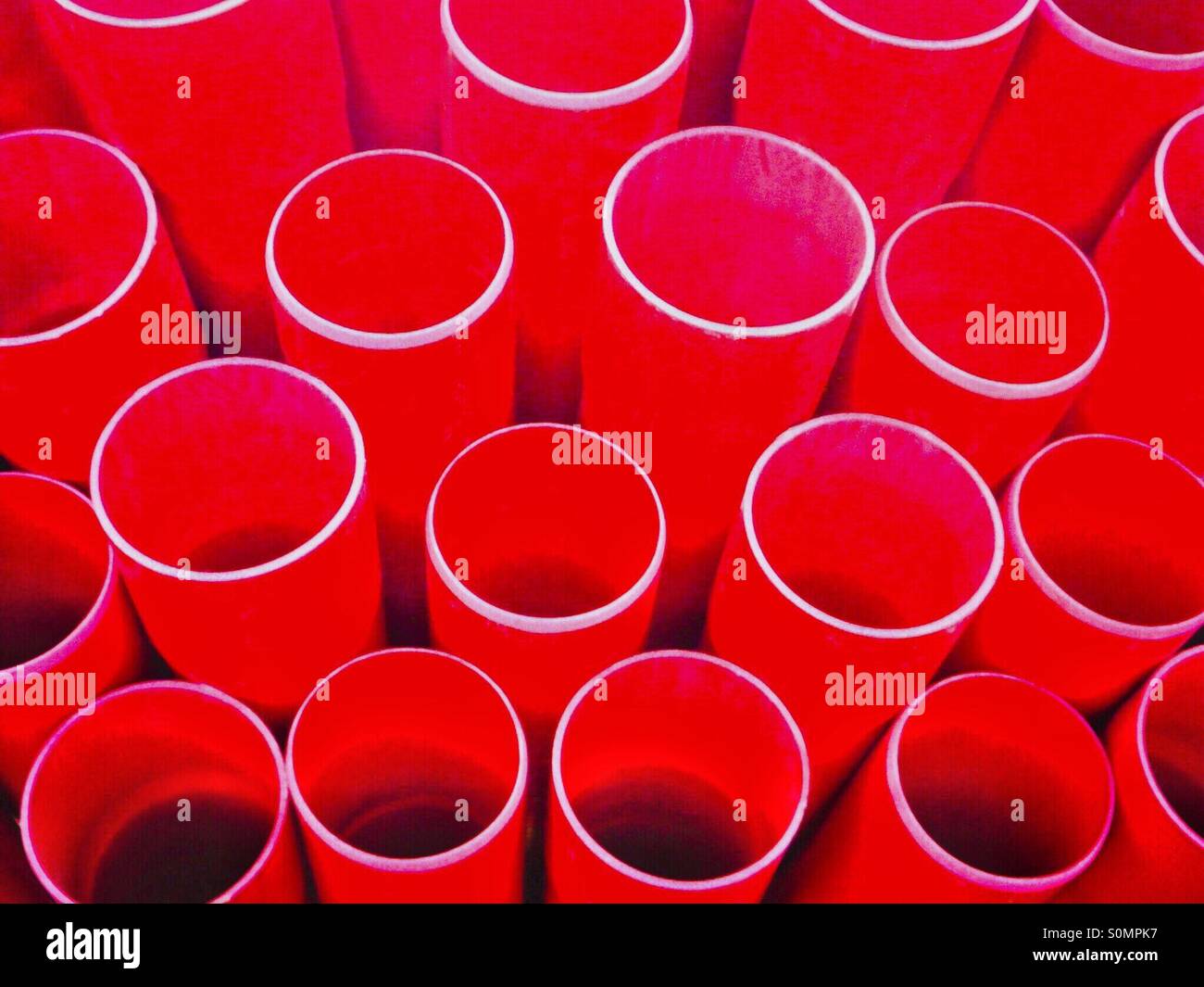 Red pipes with white circle ends Stock Photo - Alamy