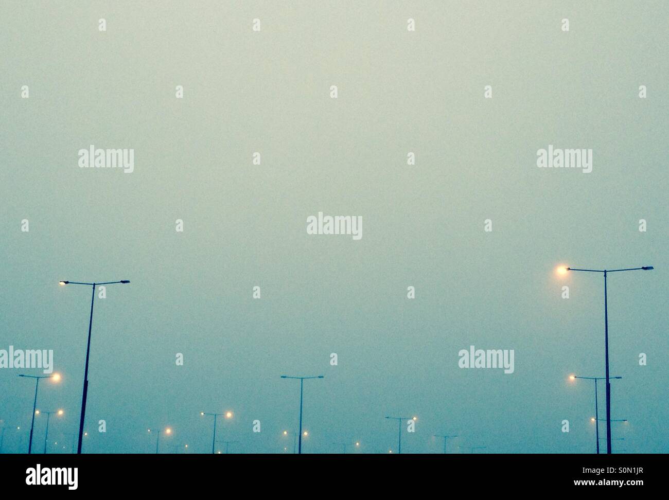 Misty morning with street lamps Stock Photo - Alamy