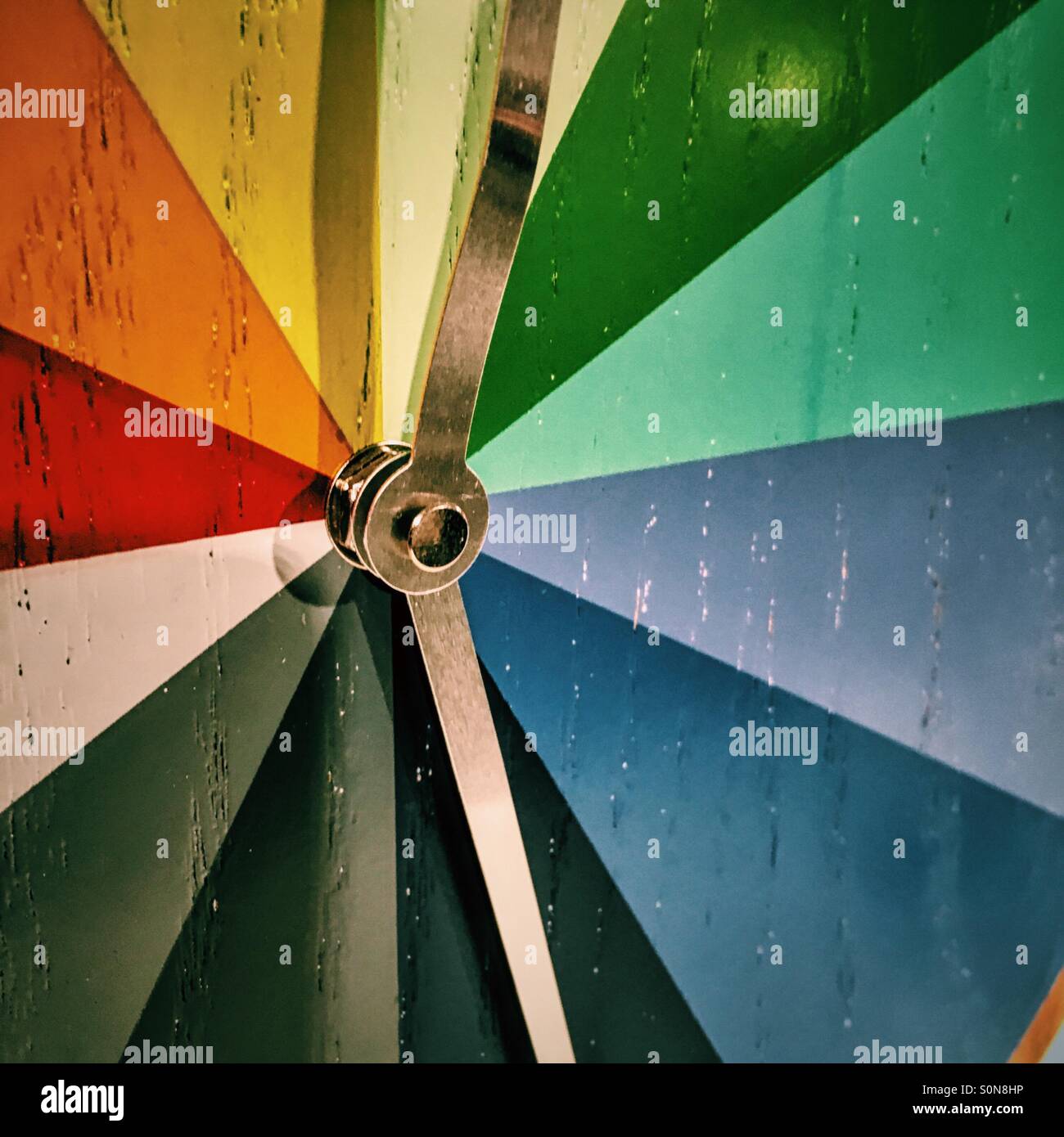 A clock adorns a colourful rainbow Stock Photo - Alamy