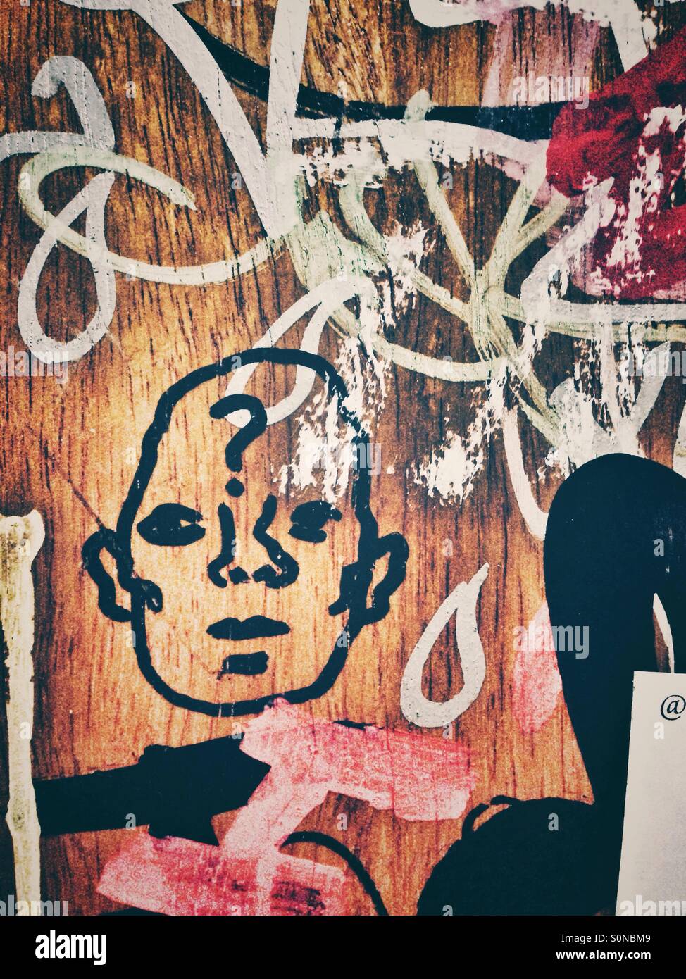 Graffiti and a drawing of a head with a question mark on the wall of a ...