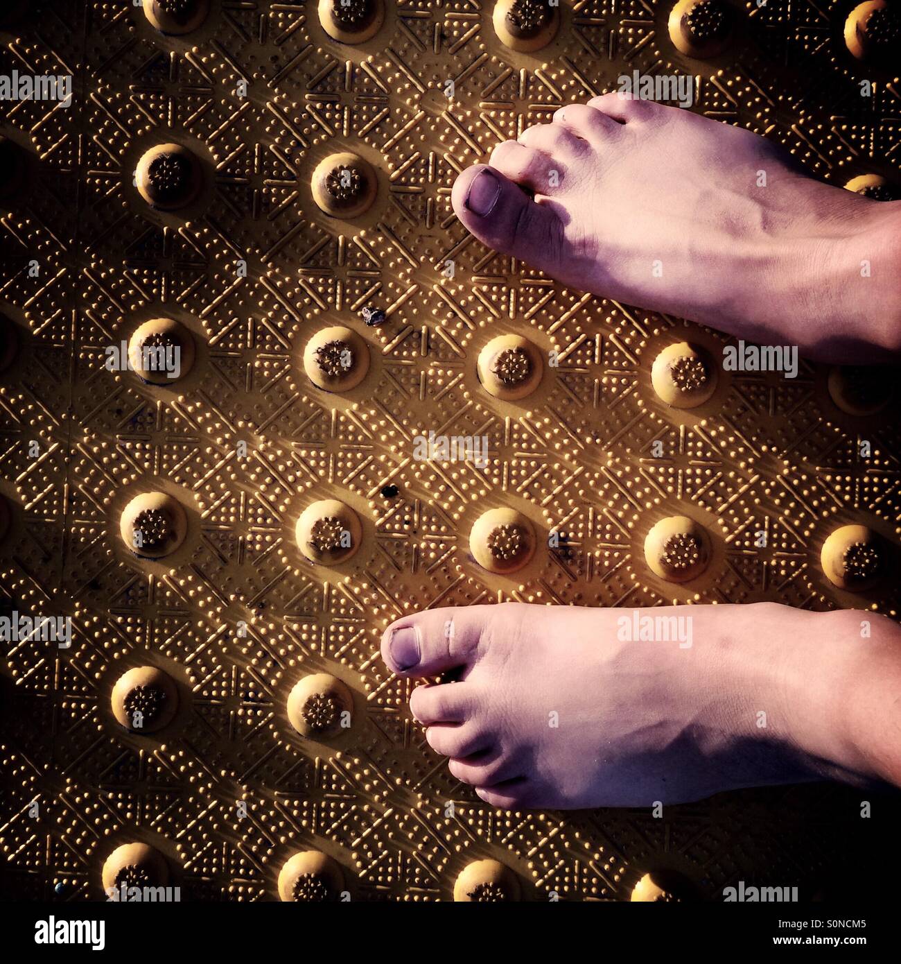 A child's bare feet on tactile bumps for the blind Stock Photo - Alamy