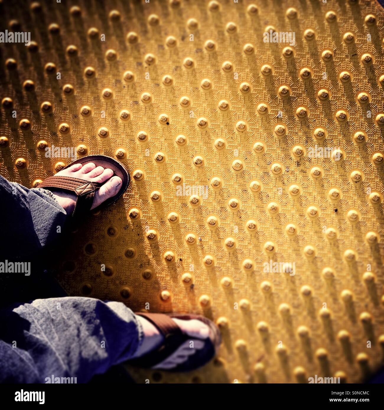 A man's feet as he stands on tactile bumps for the blind Stock Photo ...