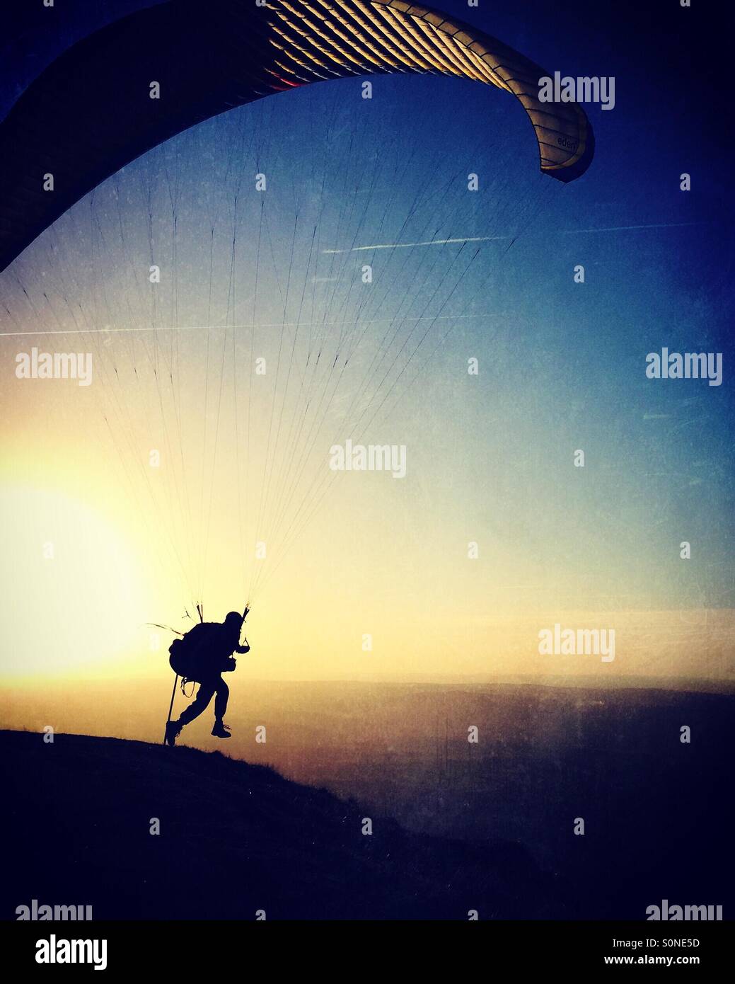 Paragliding at sunset Stock Photo - Alamy