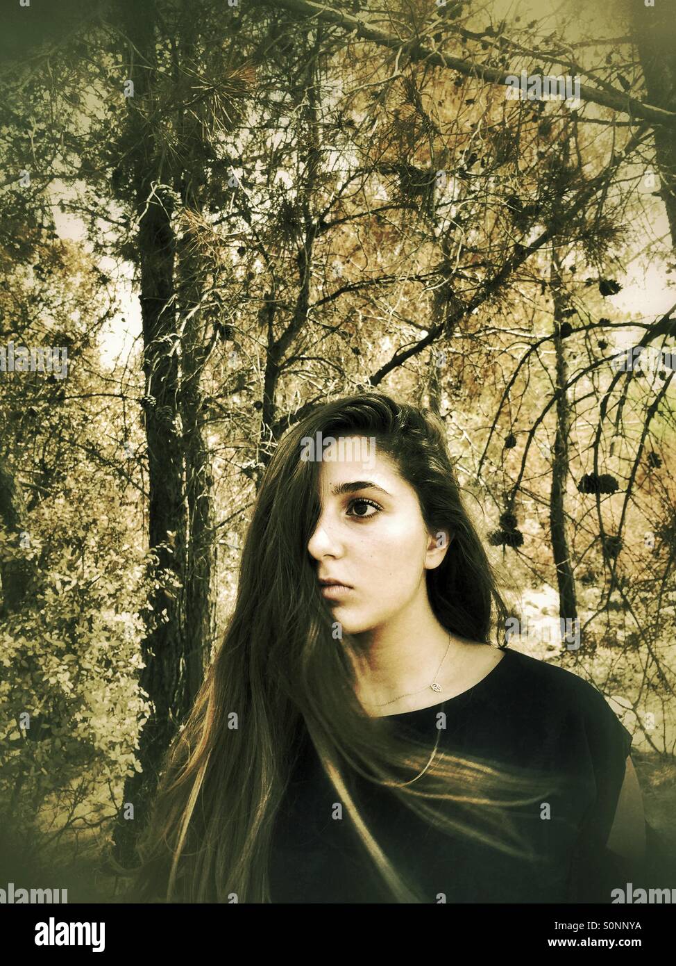 Scared teenage girl looking away in the forest Stock Photo - Alamy