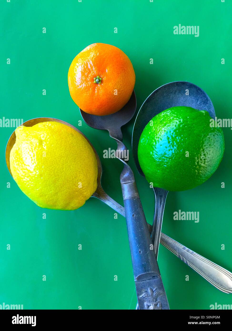 Lemon, lime and clementine on old spoons Stock Photo - Alamy