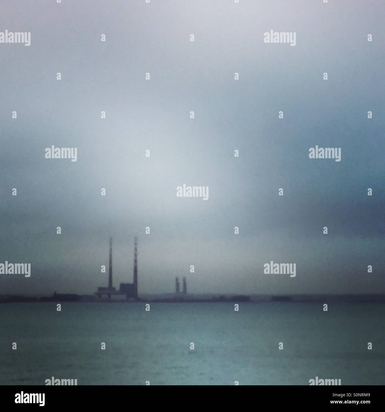 Poolbeg Generating Station chimneys viewed across Dublin Bay in Ireland ...
