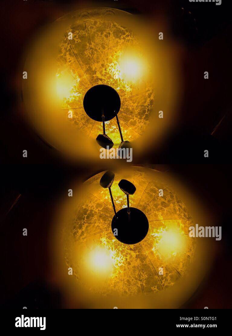 Two orbs, lit in translucent, warm glow, reminiscent of a gilded age ...
