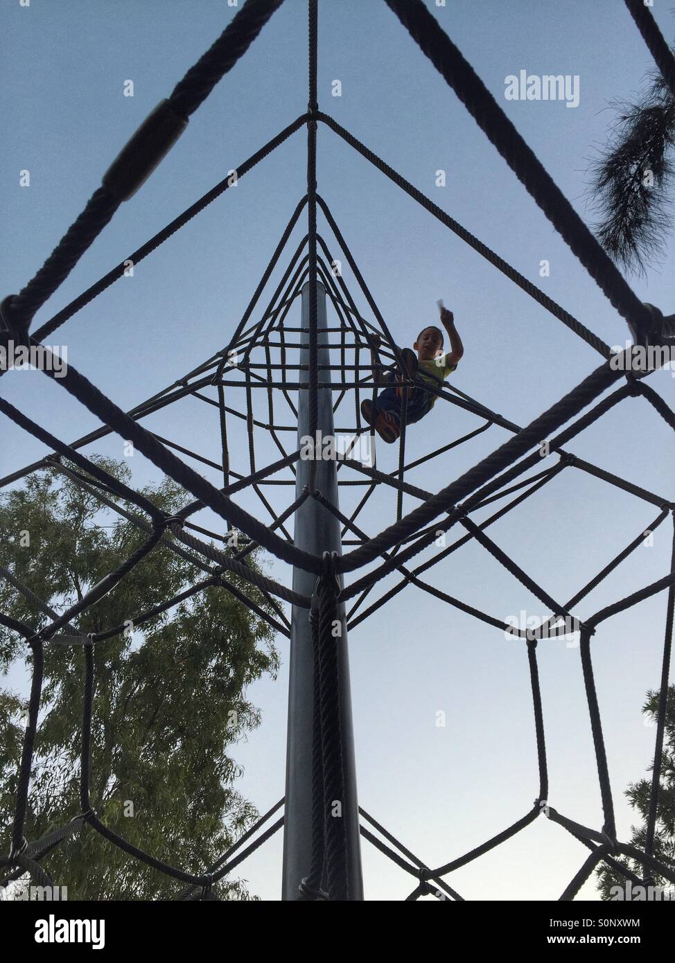 Kid climbed a spider rope shaped like spider Stock Photo - Alamy