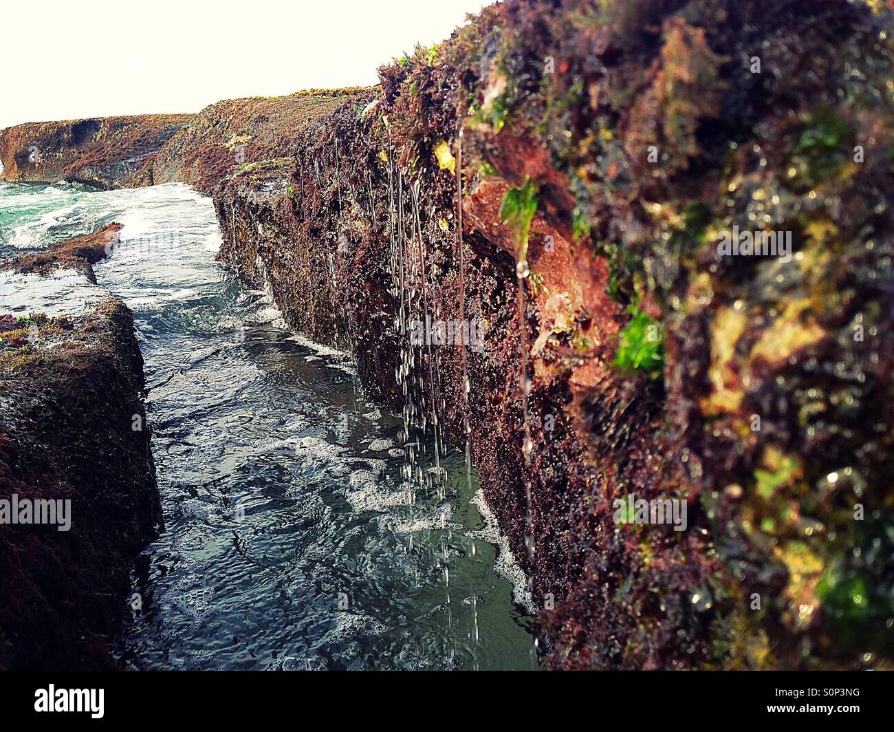 Sea water dripping over rocks Stock Photo - Alamy