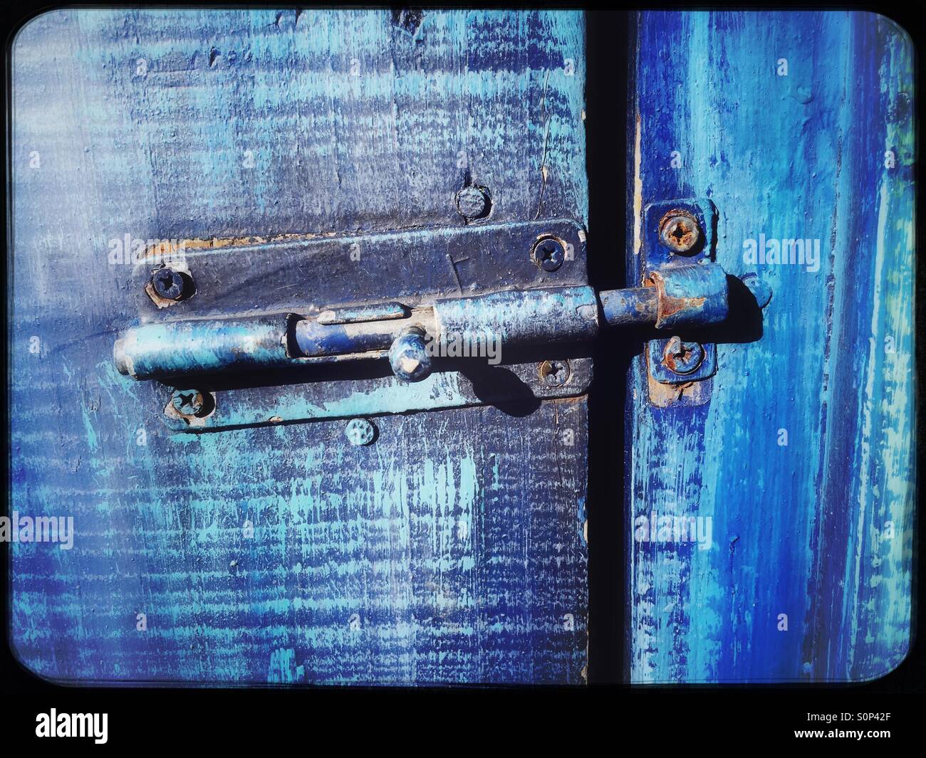 Latch on blue painted door Stock Photo - Alamy