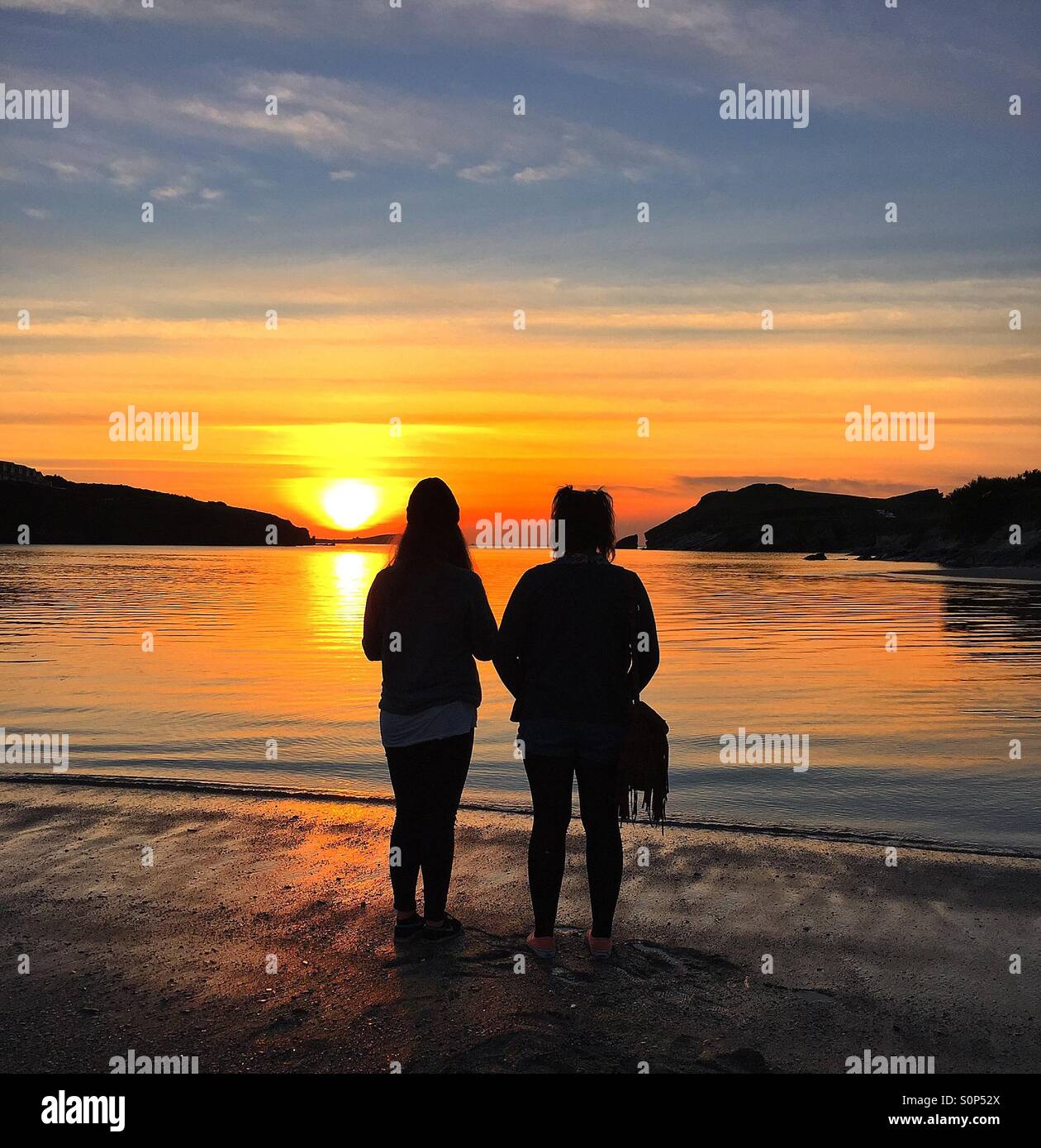 Two girls watching the sunset Stock Photo - Alamy