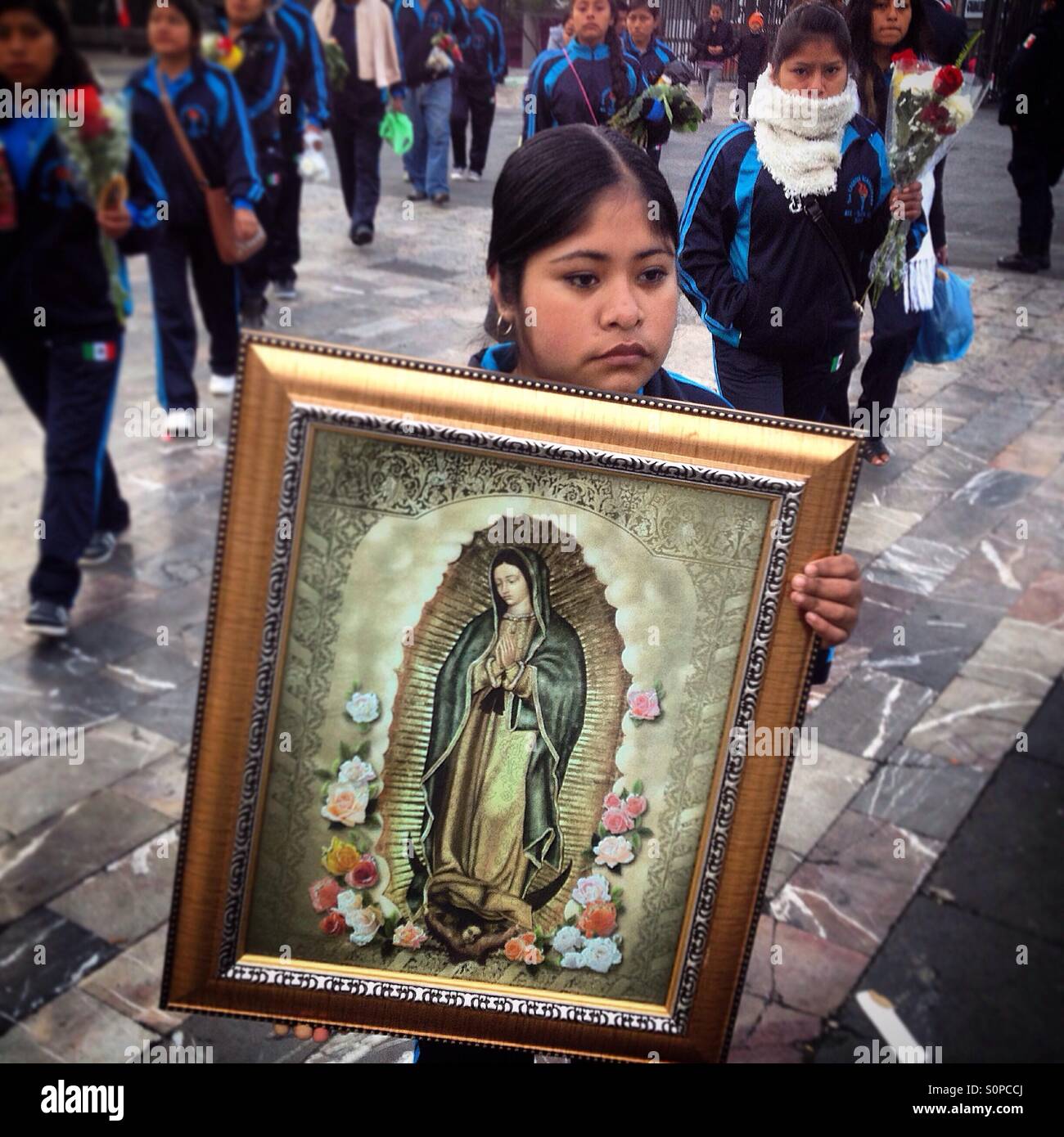 A young female pilgrim holds an image of Our Lady of Guadalupe during ...