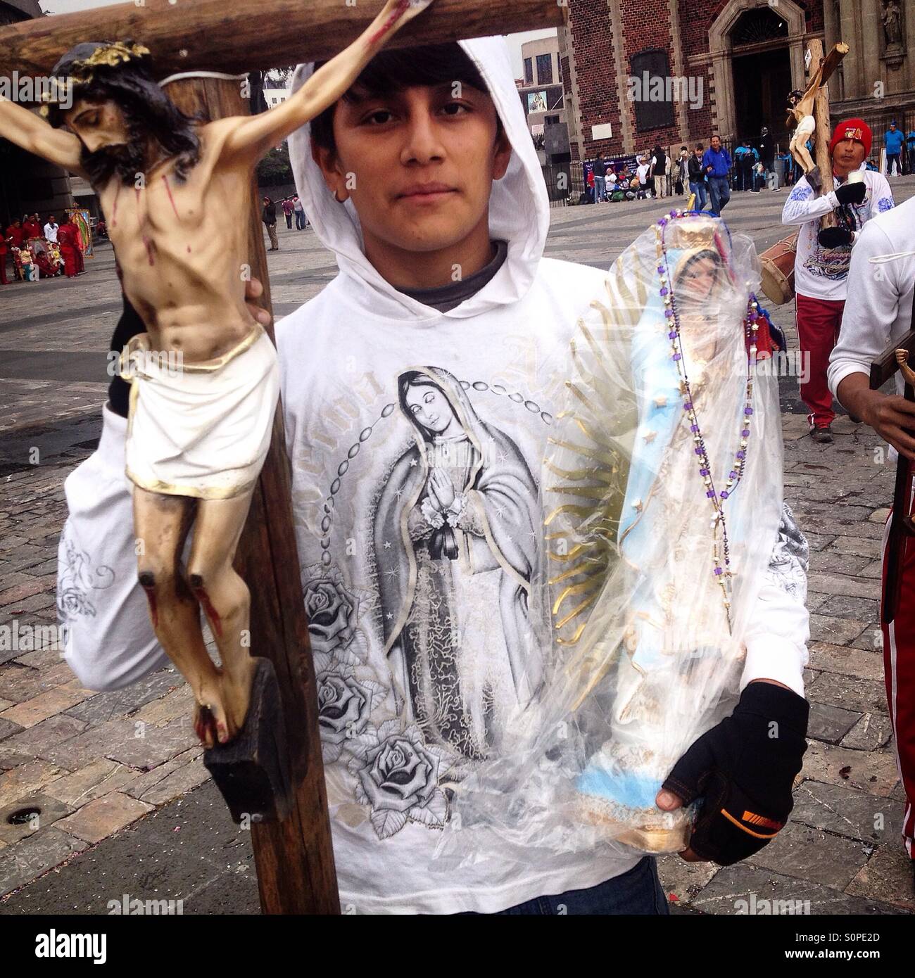 A pilgrim holds sculptures of Jesus Christ and Our Lady of Guadalupe ...