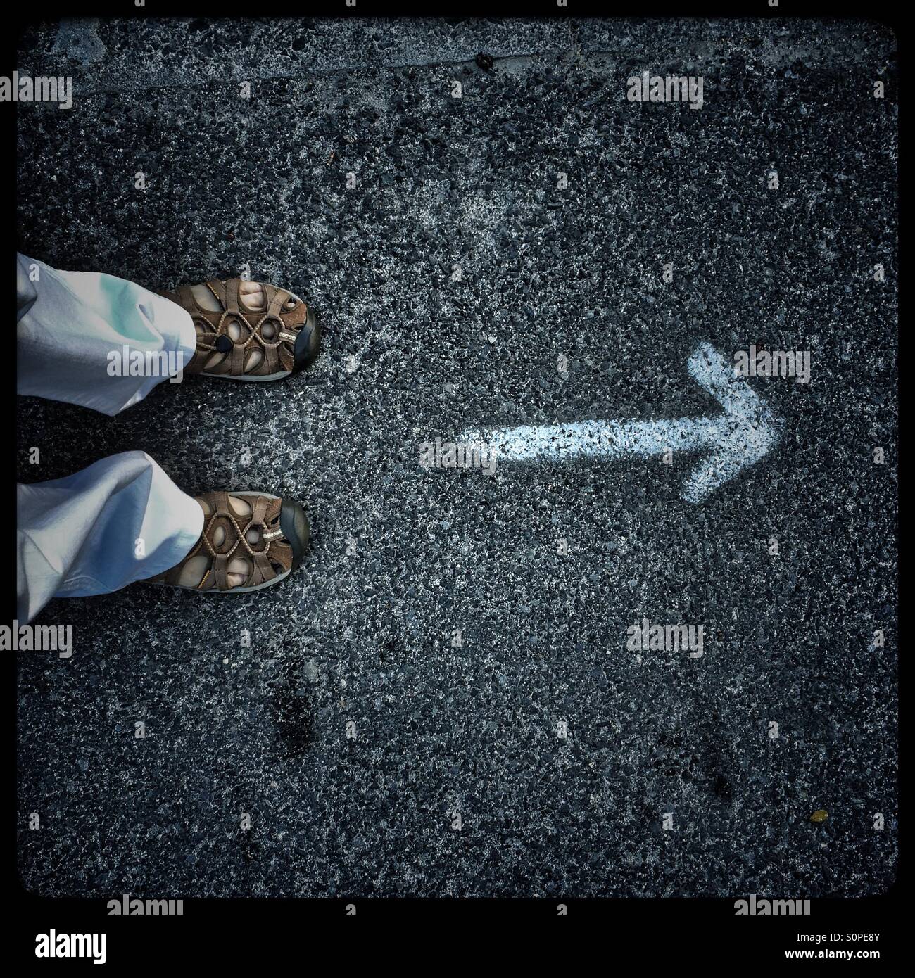 White arrow on pavement Stock Photo - Alamy