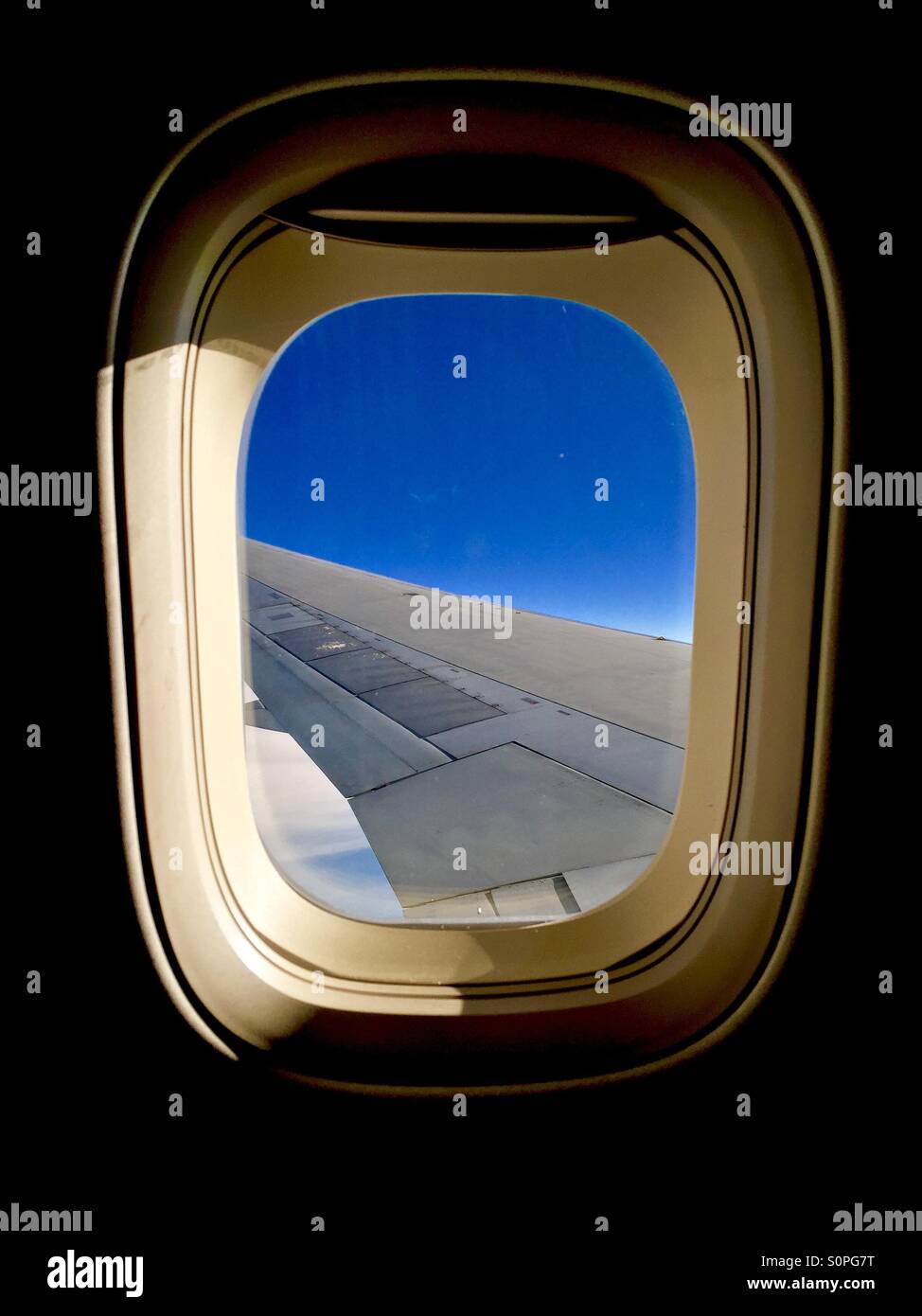 Airplane window shot of wing and sky Stock Photo - Alamy