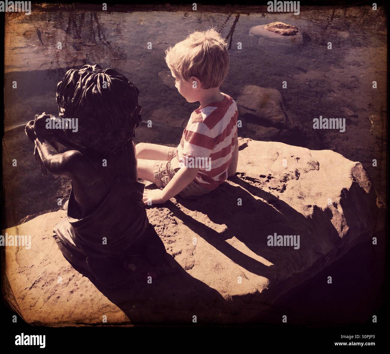 Boy and statue of a boy have a talk Stock Photo - Alamy