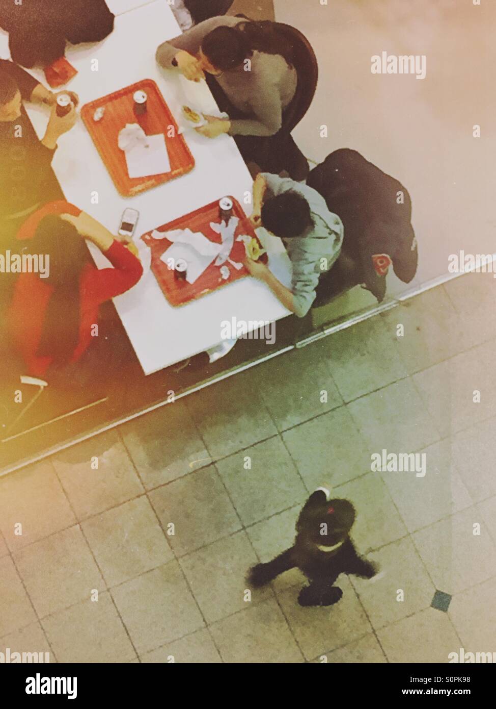 Top view of people relaxing at a table after lunch, with child running ...