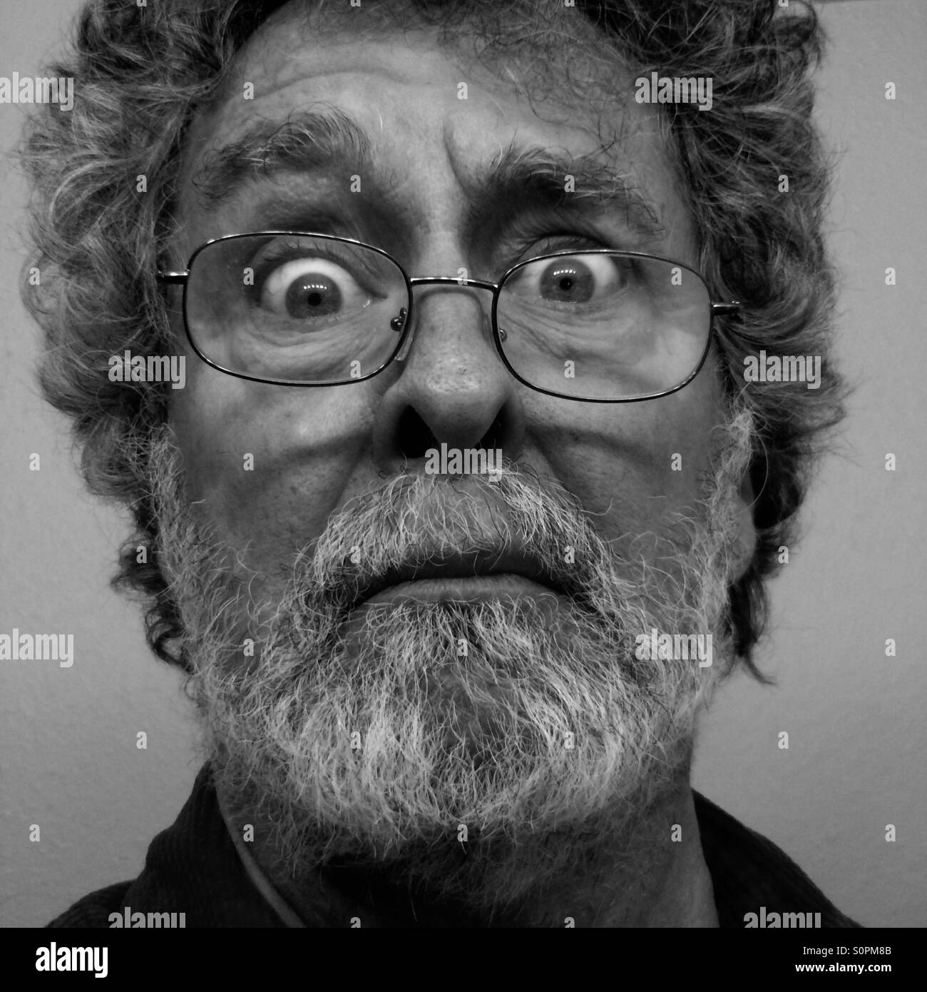 Man with glasses, age 64, with quizzical expression, black and white ...