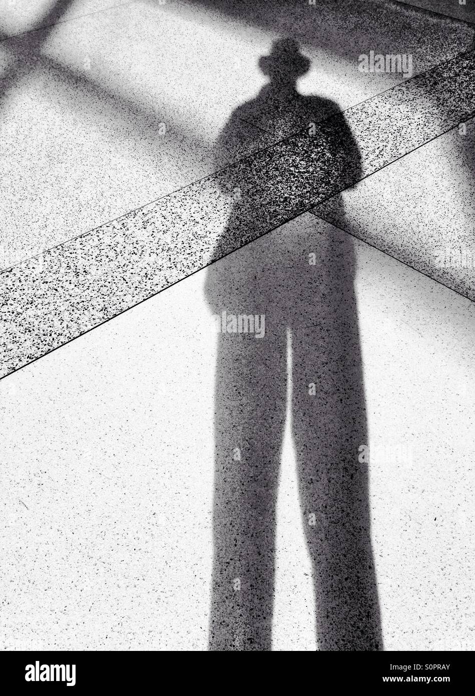 Man's shadow against geometric background Stock Photo - Alamy