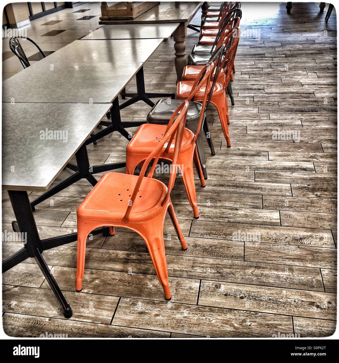 Row of orange restaurant chairs Stock Photo - Alamy