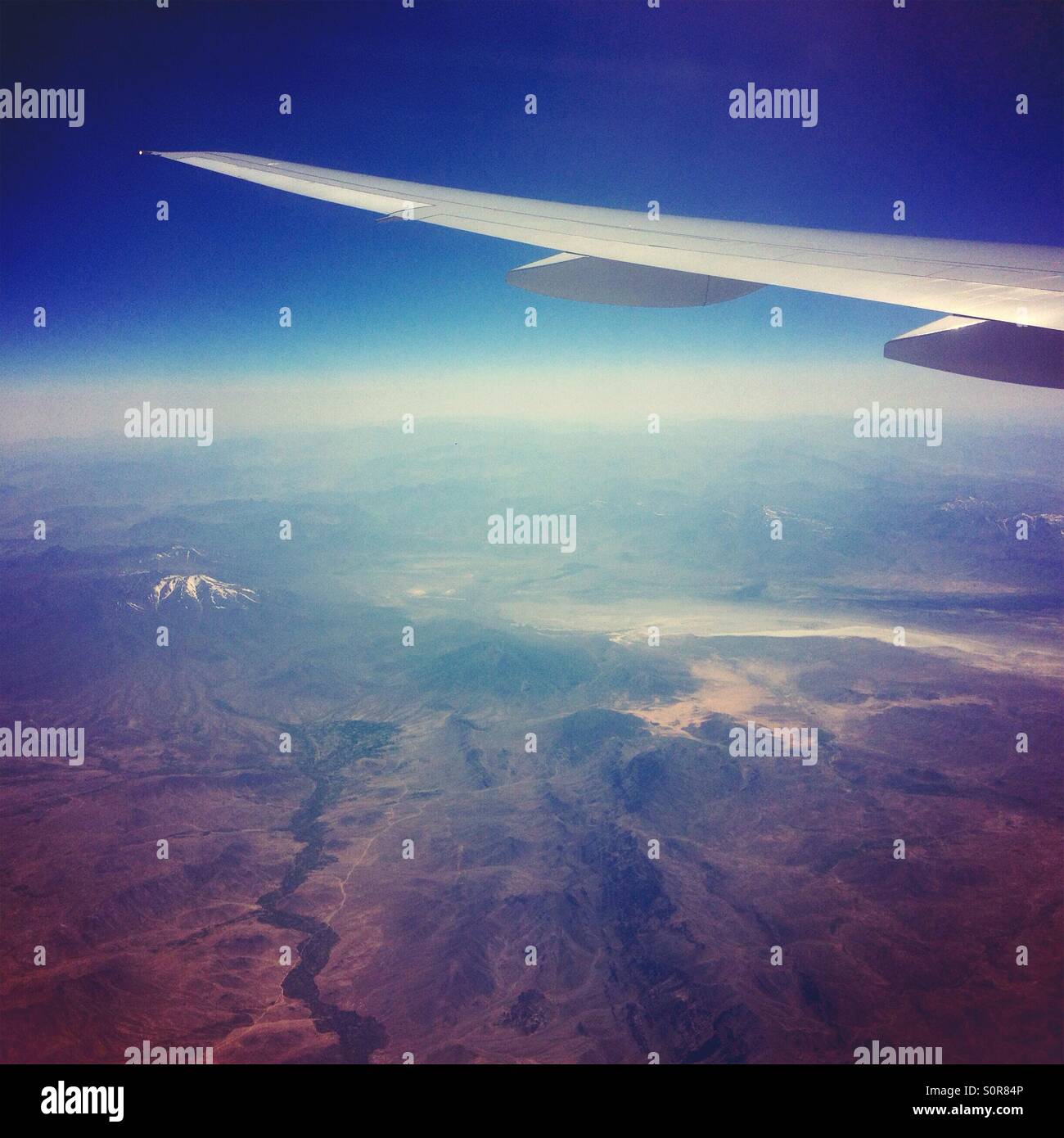 View of airplane wing flying over mountains Stock Photo - Alamy