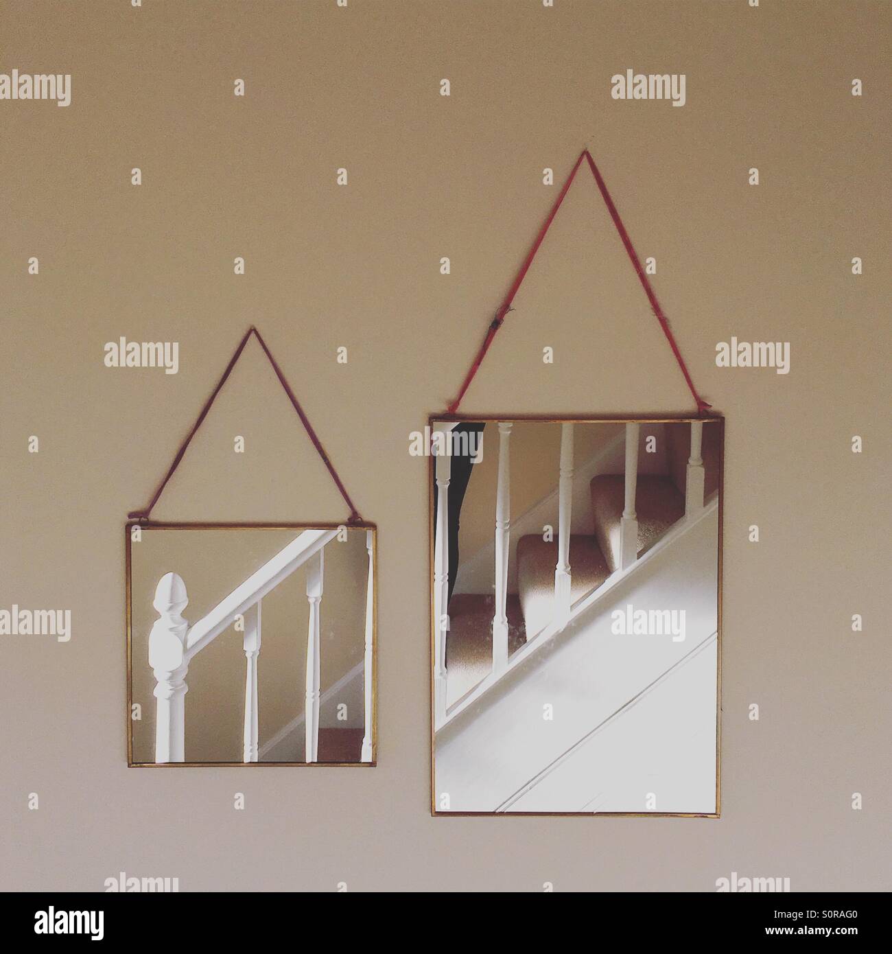 Two mirrors hanging on a wall Stock Photo - Alamy