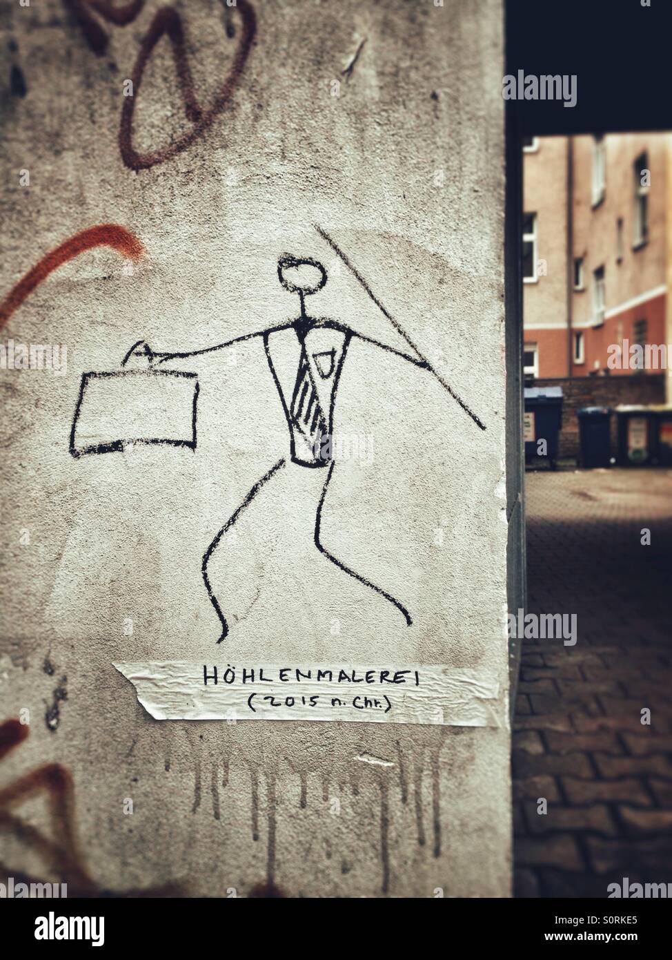 Modern caveman on a wall in Berlin, Germany: businessman stickfigure ...