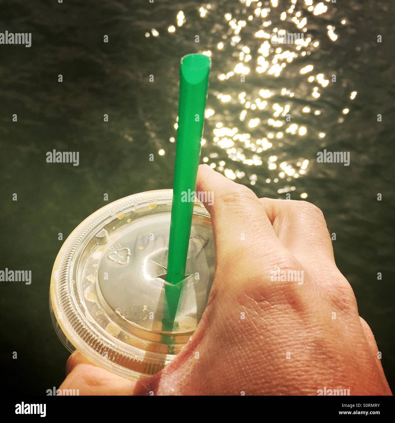 A hand holding a plastic cup Stock Photo - Alamy